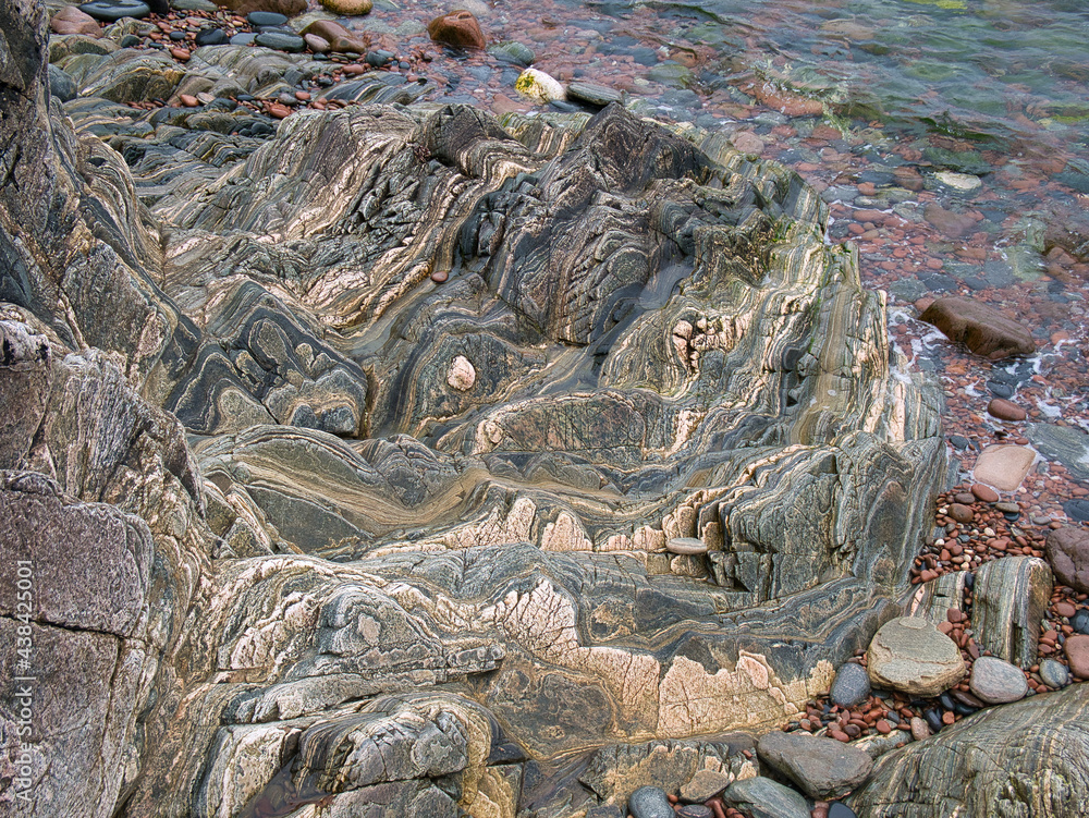 Highly folded stratified layers of rock at sea level on the Ness of ...