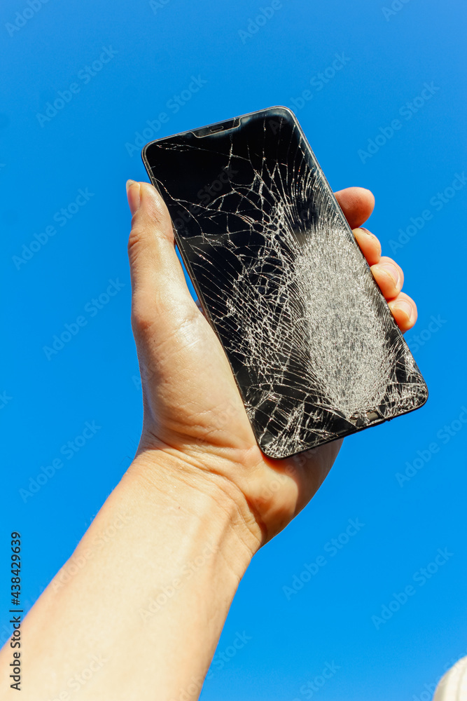 A black smartphone with a cracked screen from falling to the ground was ...