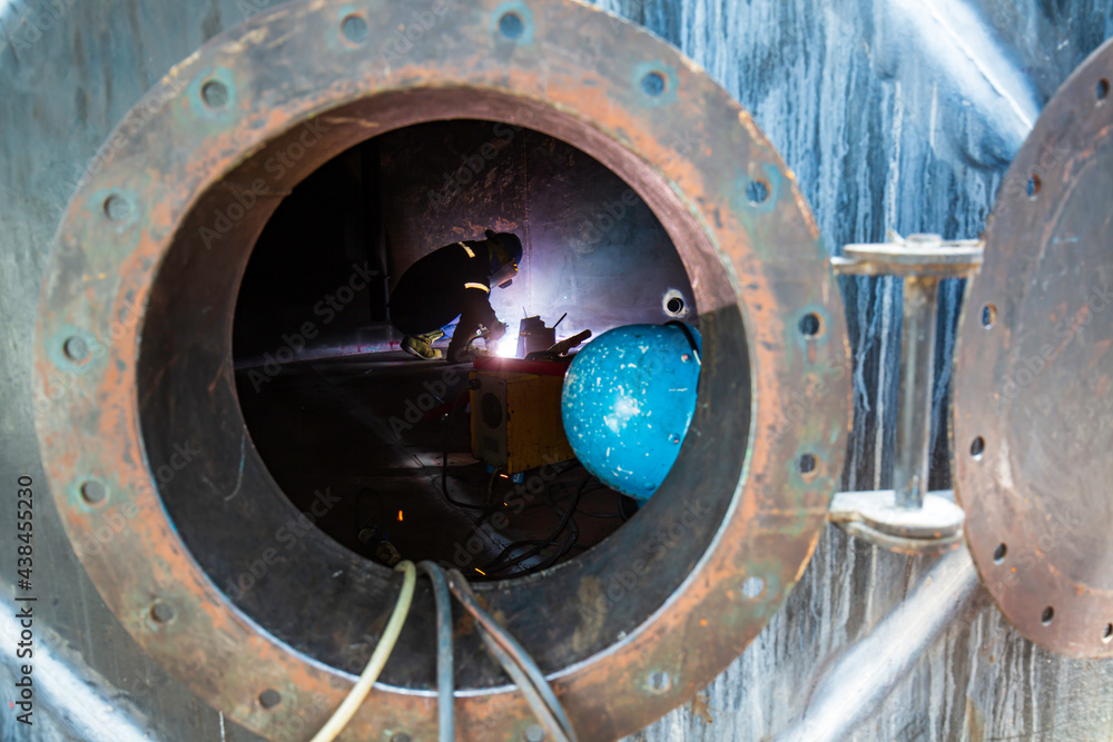Male worker wearing protective clothing and repair welding sparks ...