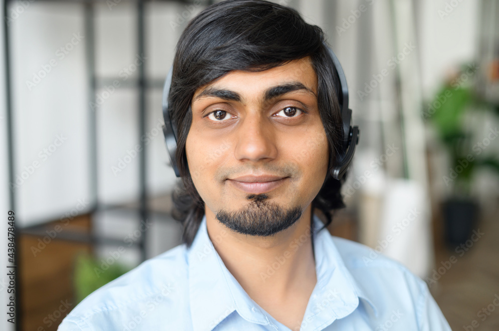 Close-up portrait of indian male support worker wearing wireless ...