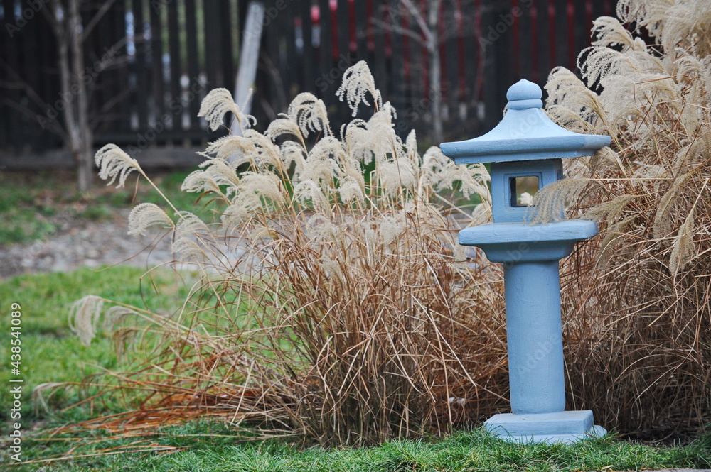 Japanese-style stone lantern among various plants in the botanical ...