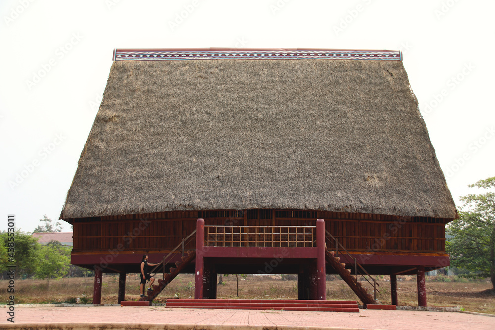 A tourist exploring a traditional architecture of a Bahnar ethnic stilt ...