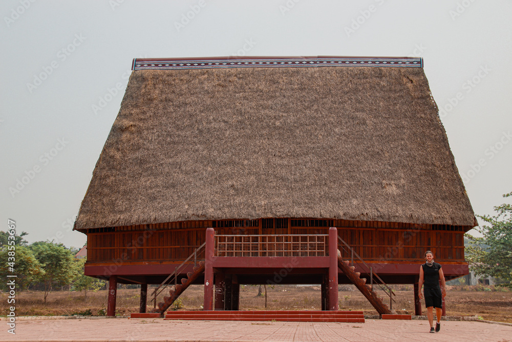 A tourist exploring a traditional architecture of a Bahnar ethnic stilt ...