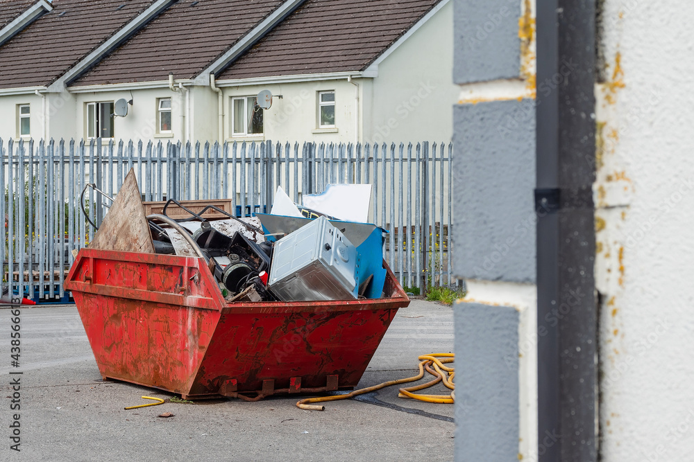 Red garbage removal skip full of rubbish and ready for collection in a ...
