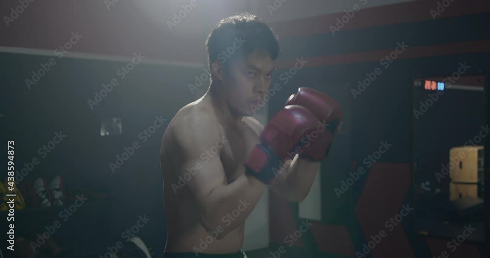 Boxer man fighting with red boxing gloves punching air exercise ...