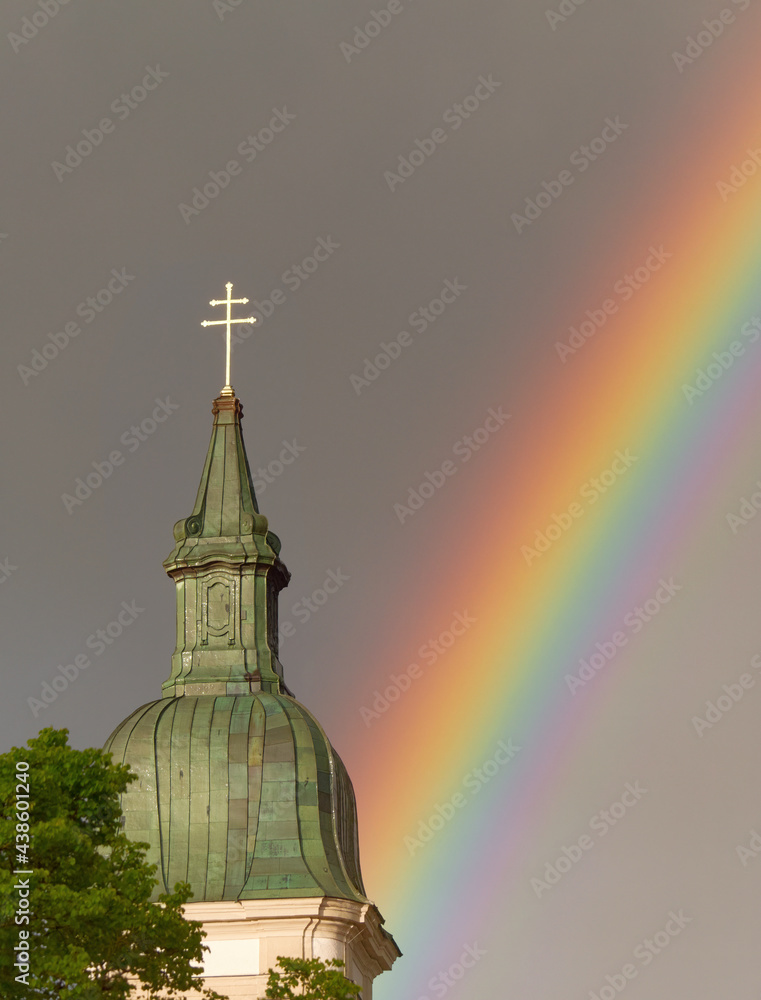 A colorful rainbow behind a german church spire as a positive symbol of ...
