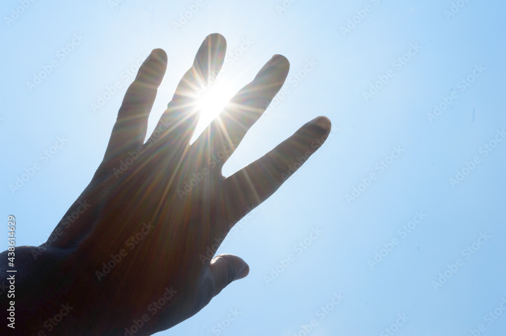Hand reaching sun light. Sunlight rays coming through human hand ...