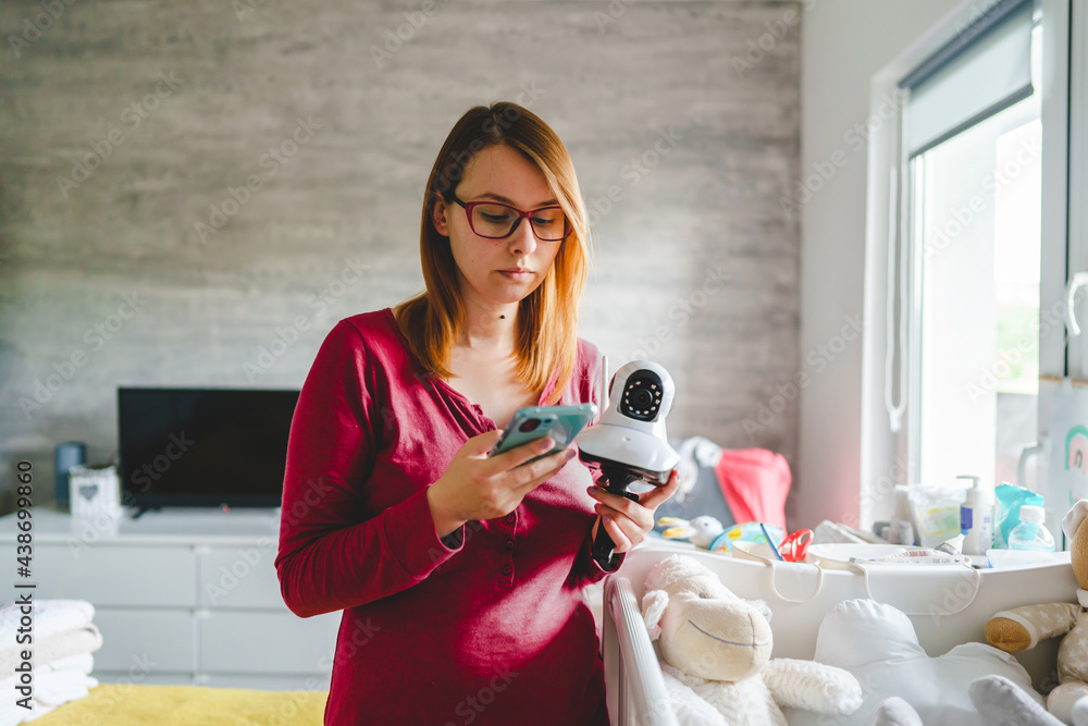 Caucasian woman mother adjusting and setting up Surveillance security ...