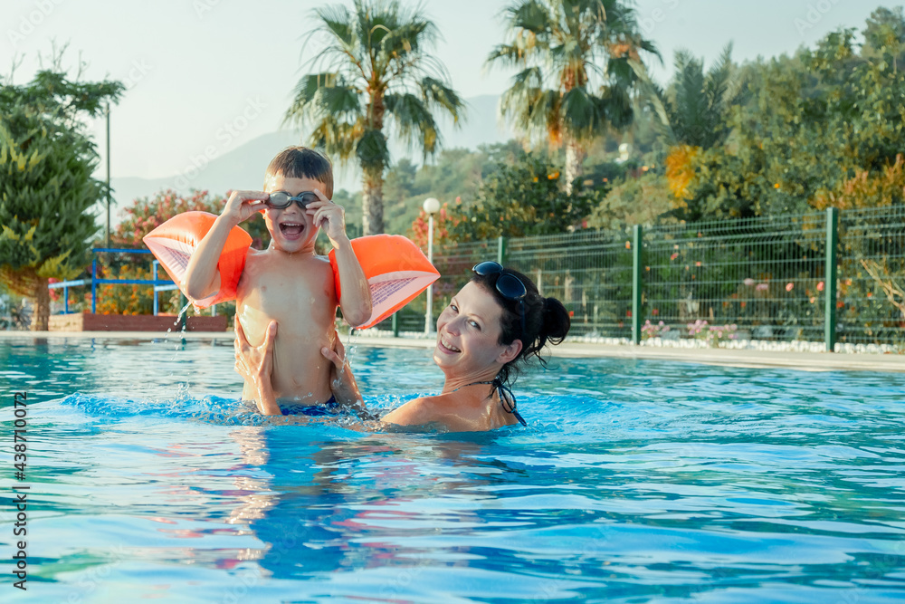 Mother and son in outdoor swimming pool. Kid learning to swim. Mom and ...