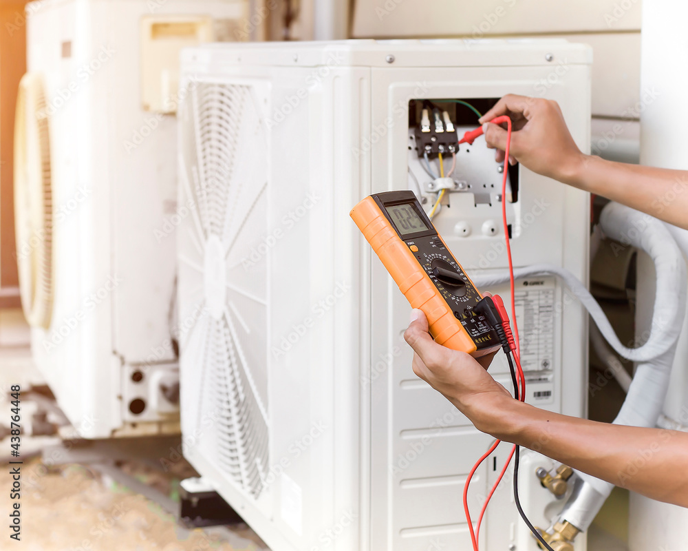 Air conditioner repairman using electricity meter to check air ...