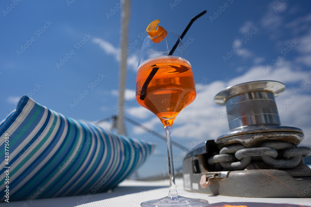 Aperol spritz cocktail drink on the boat deck next to pillow and anchor ...