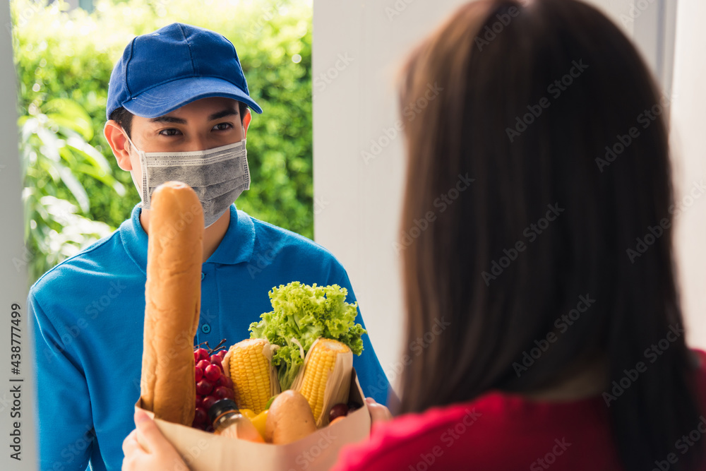 Asian young delivery man in uniform wear protective face mask he making ...