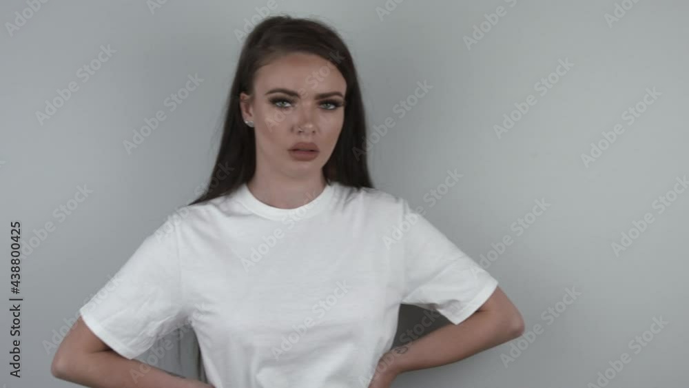 Unhappy and irritated woman in white t-shirt shows her frustration ...