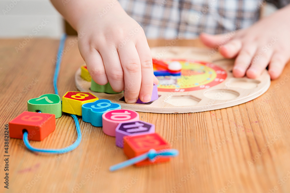 Kid playing with wooden clock numbers. different number matching to ...