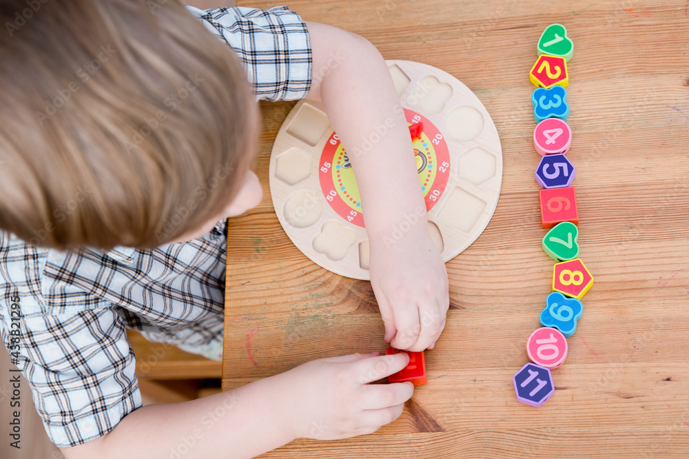 Kid playing with wooden clock numbers. different number matching to ...