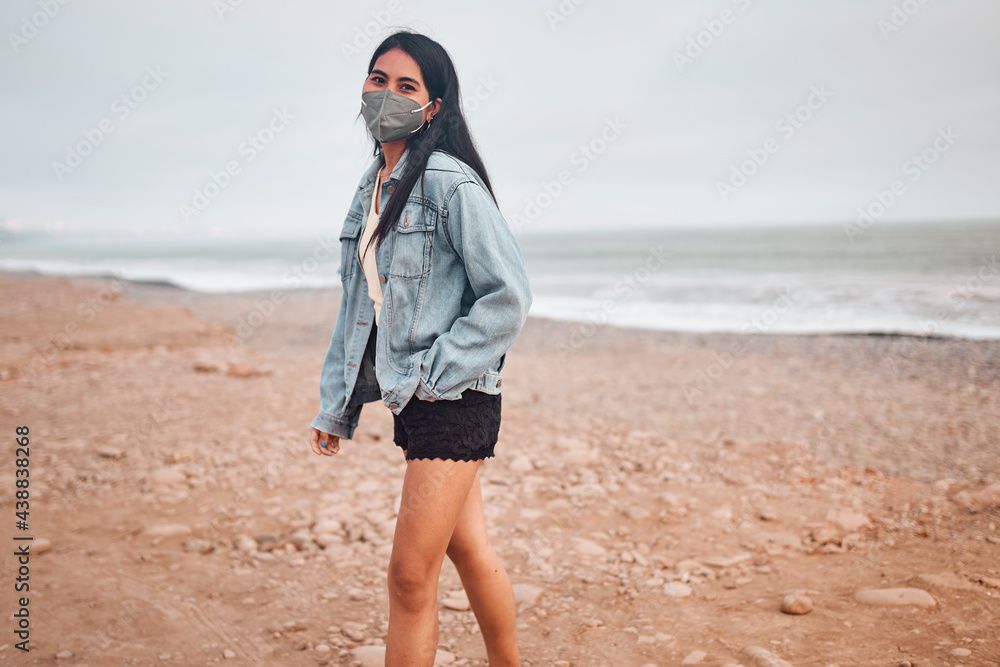 Mujer Joven latina posa caminando en la arena durante un bello ...