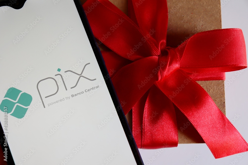 Bahia, Brazil - October 9, 2020. Pix logo on smartphone screen and gift ...