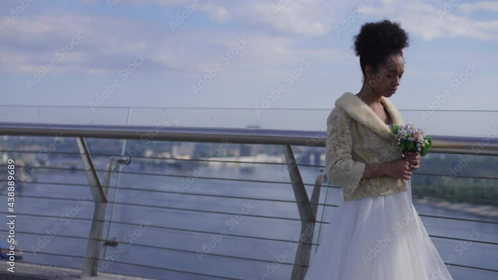 Frustrated beautiful African American woman in wedding dress putting ...