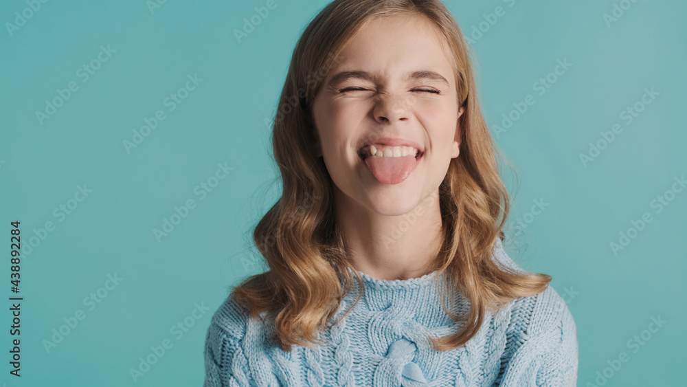 Pretty teenage girl with wavy hair showing tongue on camera look Stock ...