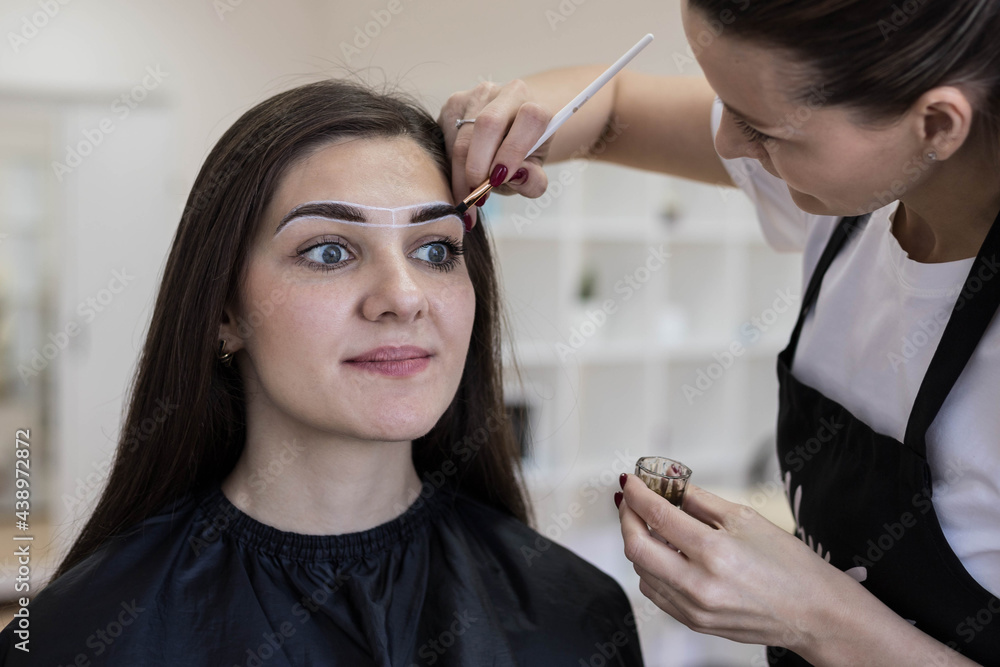 The master draws auxiliary lines between the eyebrows with a white ...