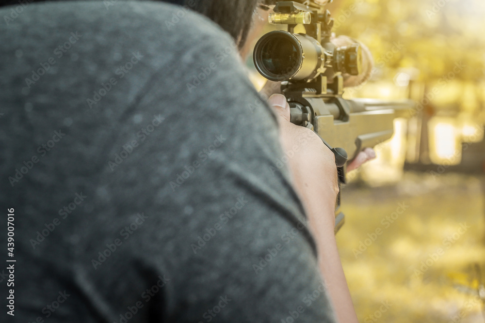 Camouflage sniper shooting rifle by looking through a scope hunting ...