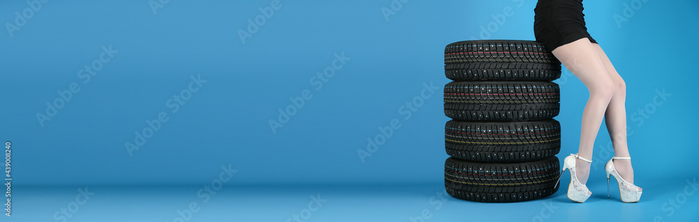 set of studded wheels and beautiful female legs on a blue background ...