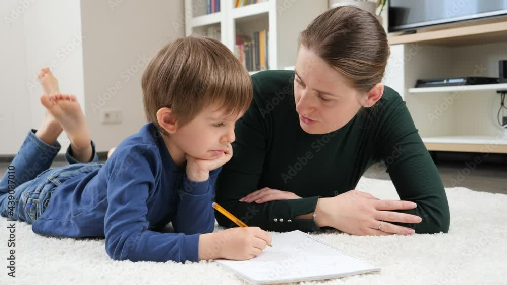 Angry mother scolding and talking to her silly son doing homework on ...