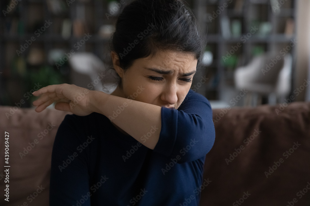 Vampire cough. Sick millennial indian woman staying ill at home sitting ...