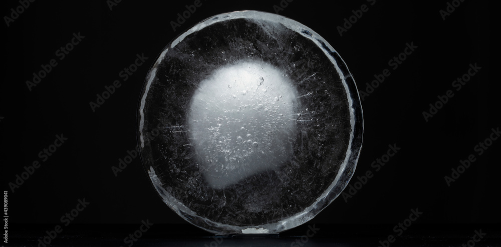 Round ice block on black background, big solid ice cube, close up ...