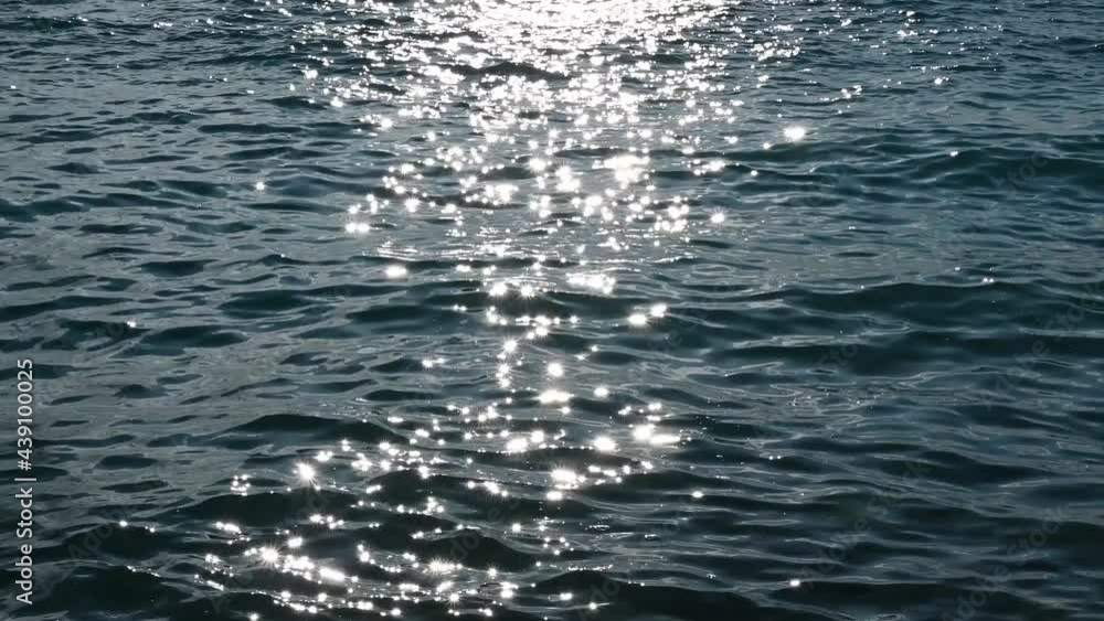 Sea waves at sunset. Sun reflection on water surface. Disturbed and ...