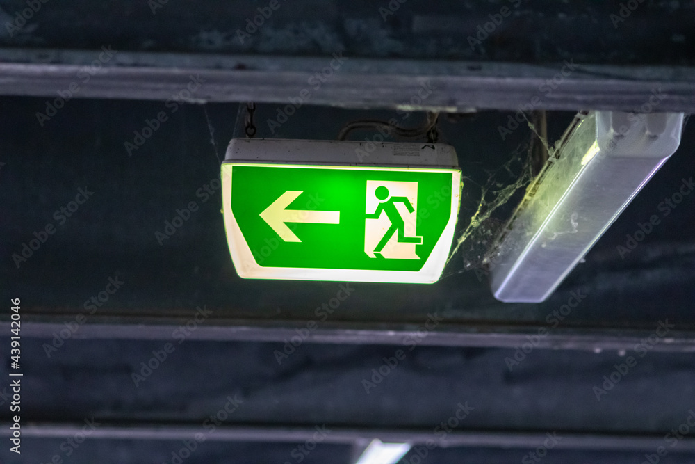 Foto de Green exit sign with running person and green arrow shows ...