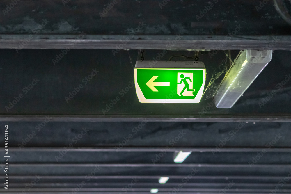 Green exit sign with running person and green arrow shows guidance ...