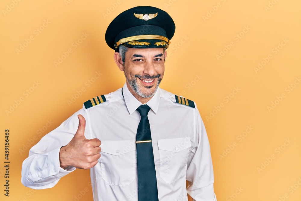 Handsome middle age man with grey hair wearing airplane pilot uniform ...