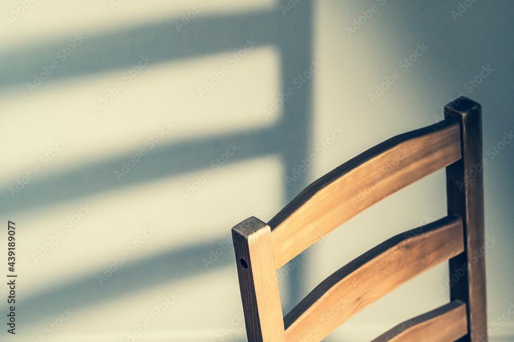 Foto de Heavily stylised wooden chair with a long shadow in a spotlight ...