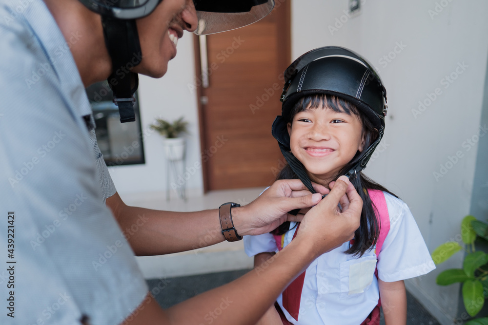 father taking his daughter to school by motorcycle in the morning ...