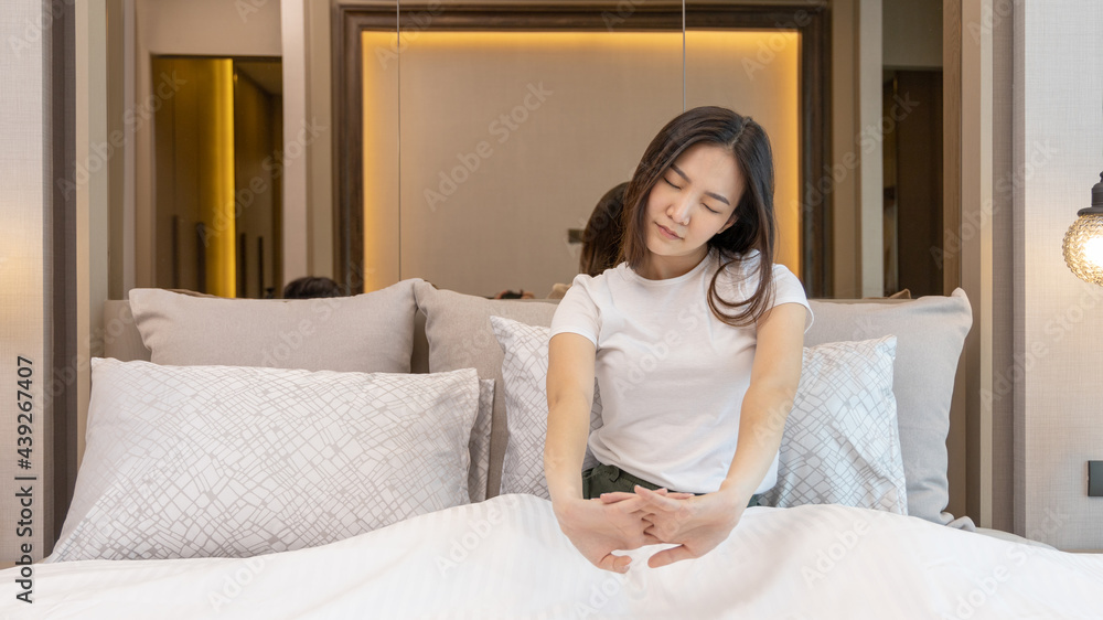 Stretch oneself, Beautiful Asian woman waking up in the morning in her ...