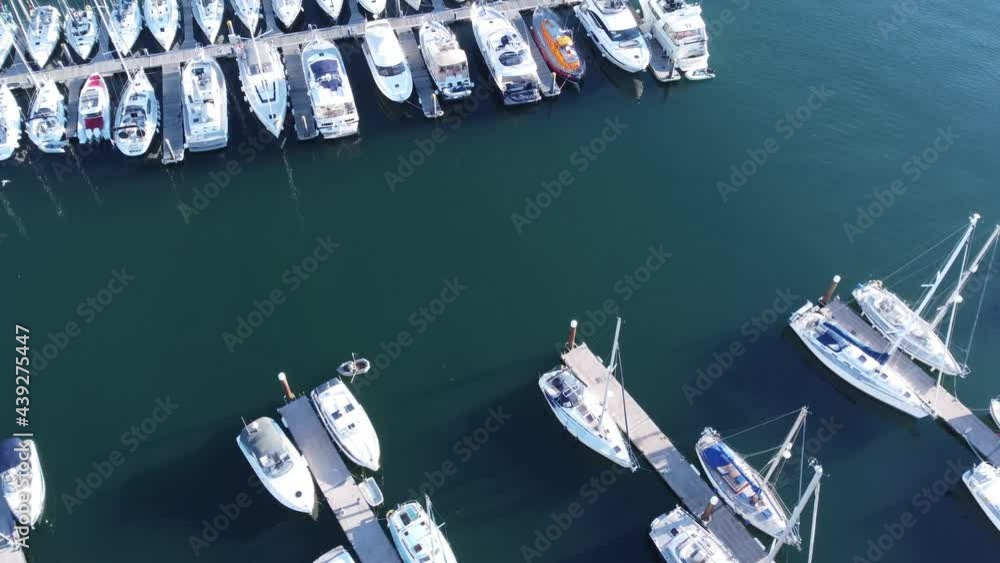 A forward flying drone shot of a marina and lots of boats, that slowly ...