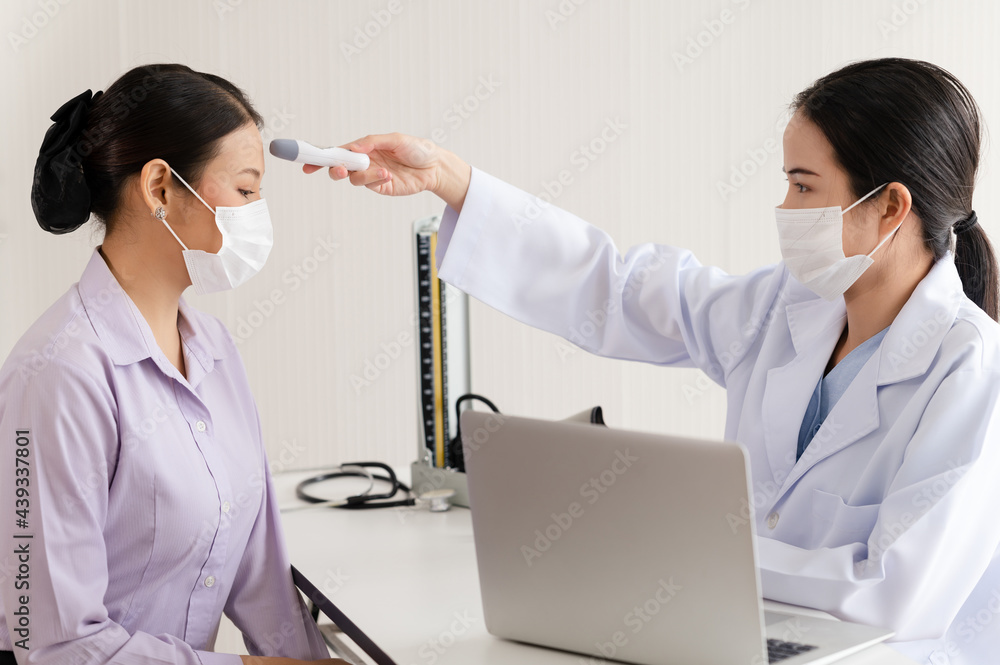 Foto de Asia Female doctor checking the temperature of a young woman ...