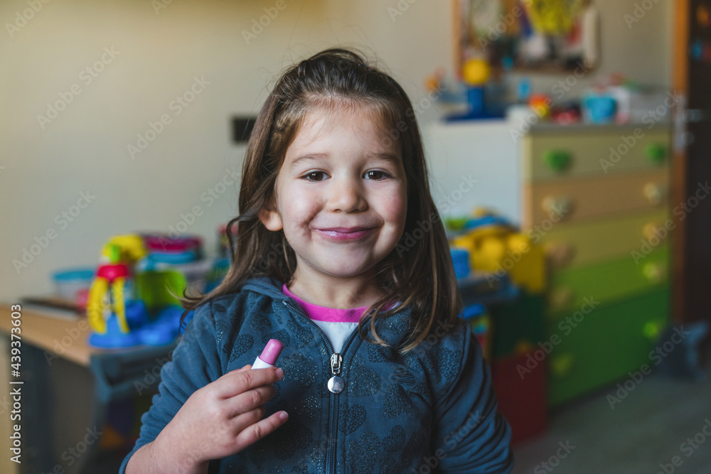 Little Girl with Cocoa Butter Lip Balm Stick Stock Photo | Adobe Stock
