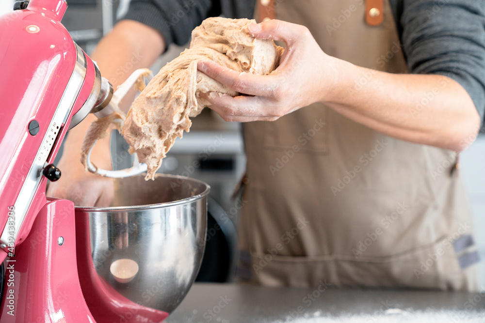Man removing bread dough from a mixer Stock Photo | Adobe Stock