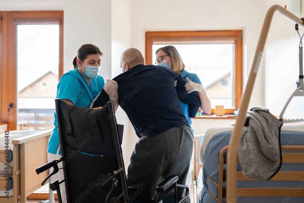 Helping Patient To Get In Wheelchair Stock Photo | Adobe Stock