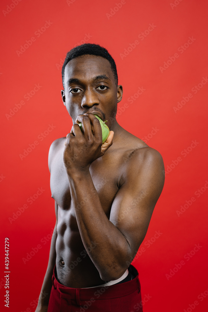 Shirtless black man biting apple Stock Photo | Adobe Stock