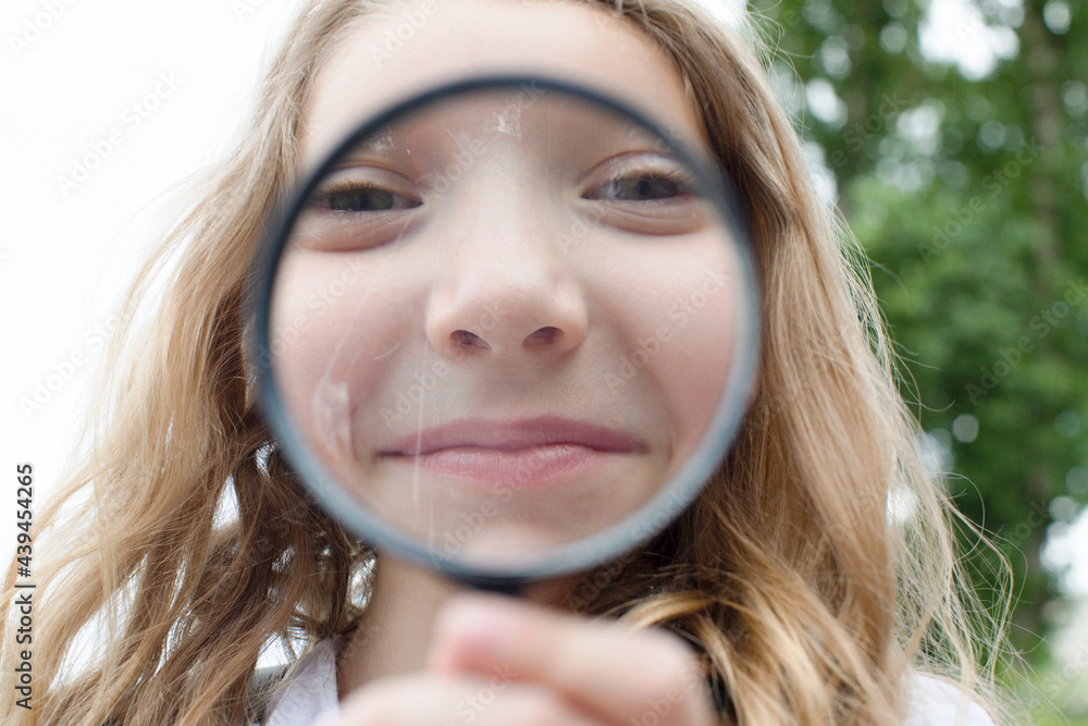 girl's face through a magnifying glass Stock Photo | Adobe Stock