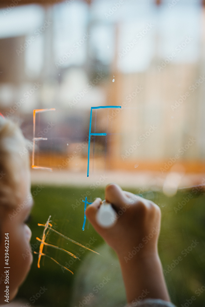 Little boy learning the alphabet with window markers Stock Photo ...