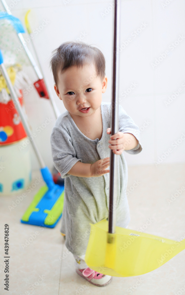 Cute Asian kid playing with broom on home balcony Stock Photo | Adobe Stock