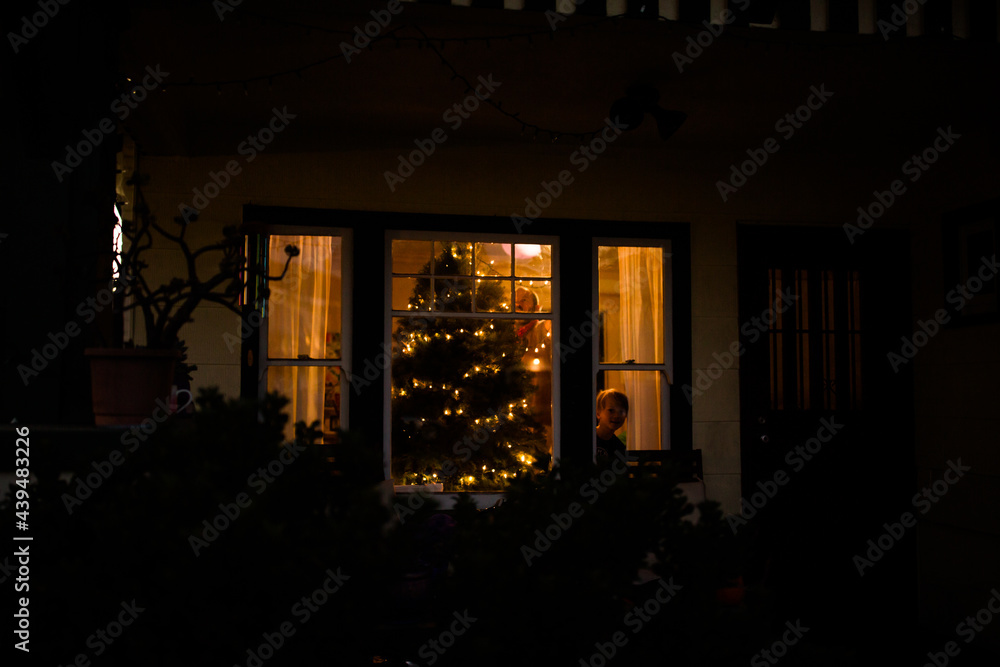 Outside view of young child peering through window while father ...