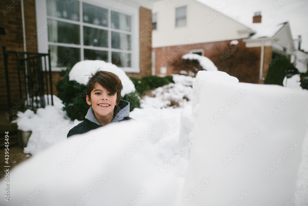 boy hides behind snow fort for snowball fight Stock Photo | Adobe Stock
