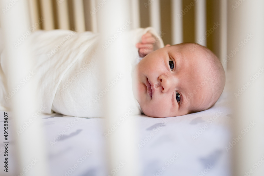 baby peeks through bars of crib Stock Photo | Adobe Stock