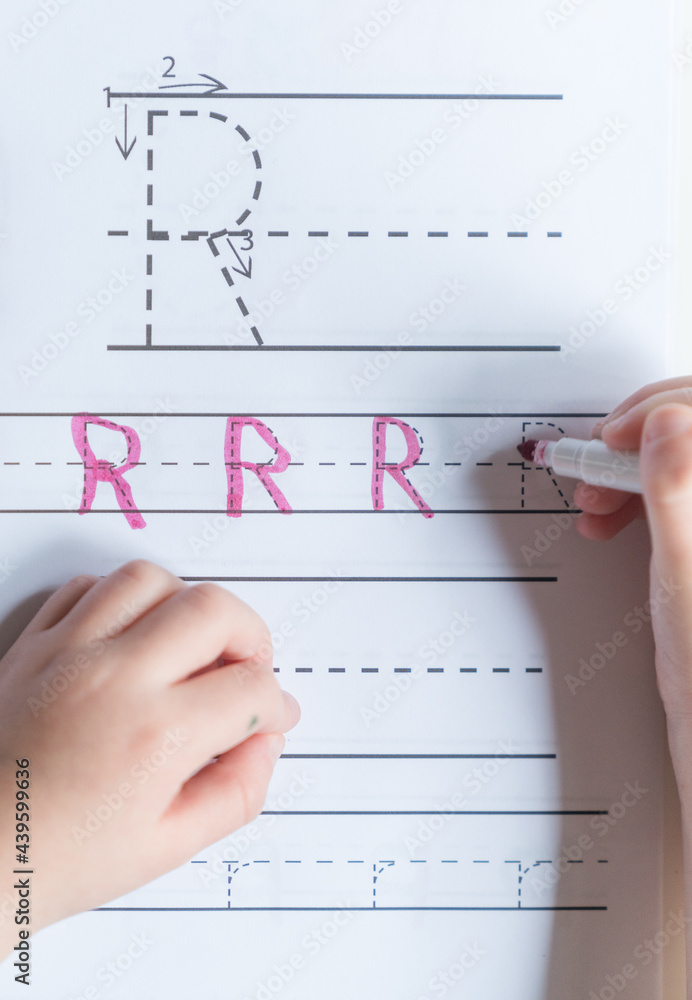 preschooler learns writing the letter R Stock Photo | Adobe Stock