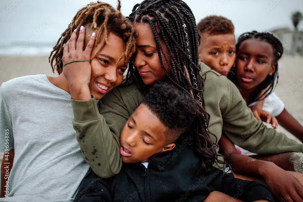 Mother hugging children at beach Stock Photo | Adobe Stock
